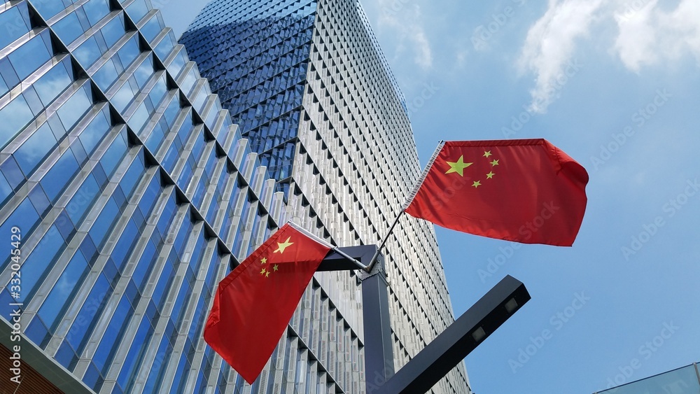 China country flags waving by the modern glass commercial building ...
