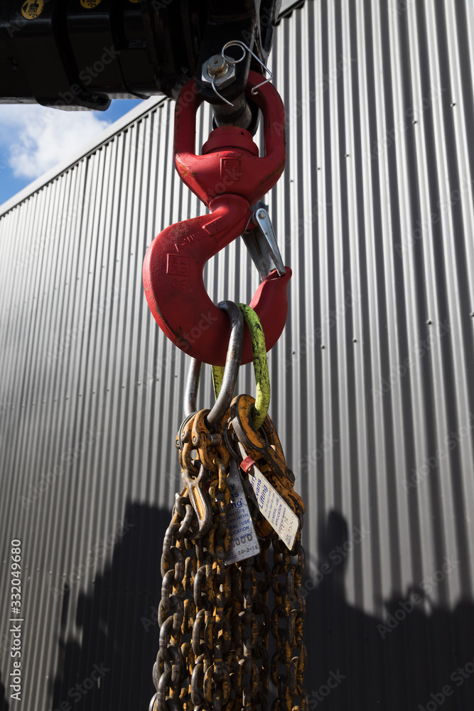 Detail of a red hook, shackle and chain. Part of a mobile crane for ...