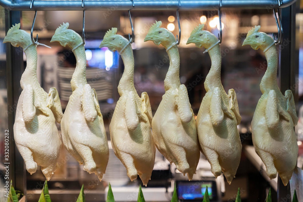 group of raw chicken in a store, beautifully and neatly hung in one row ...
