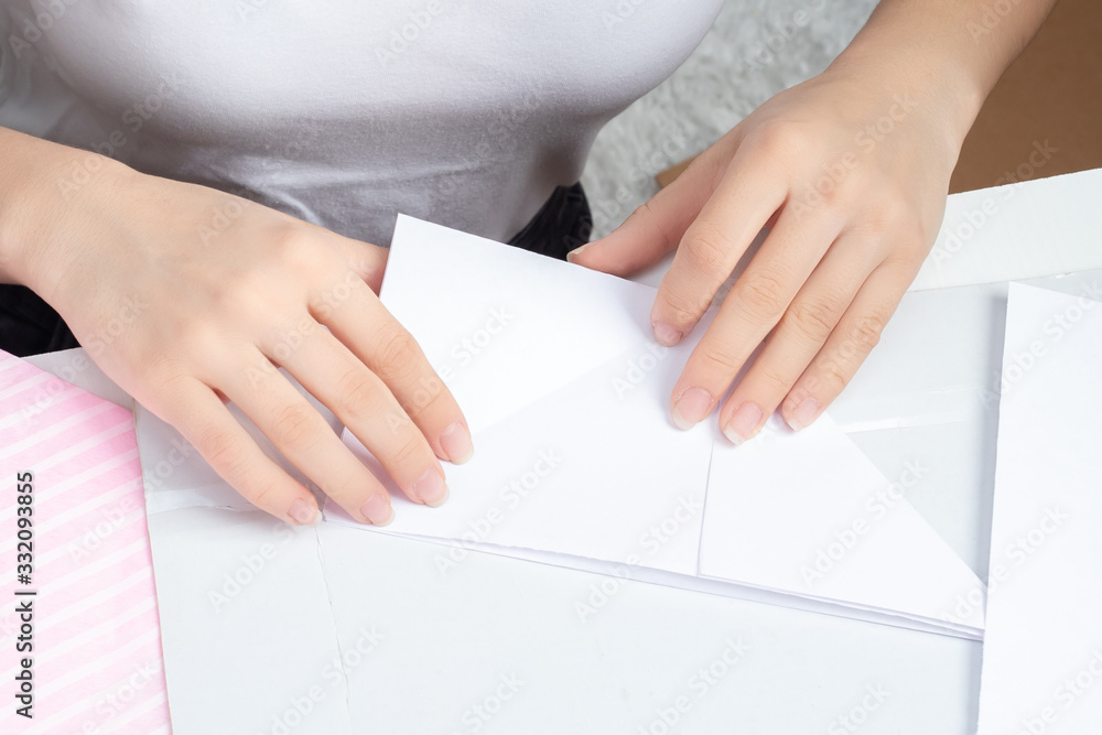 Origami is an ancient Chinese art of folding paper. Female hands make a ...