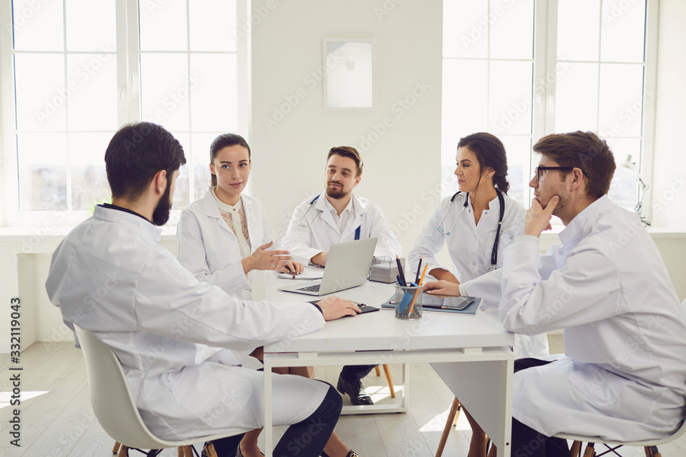 Group of practicing doctors in a meeting discuss the diagnosis of a ...