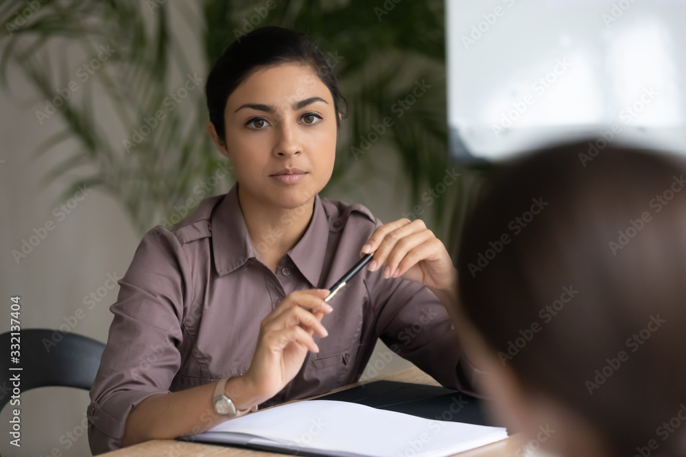 Serious Indian female employee engaged in team brainstorming at office ...