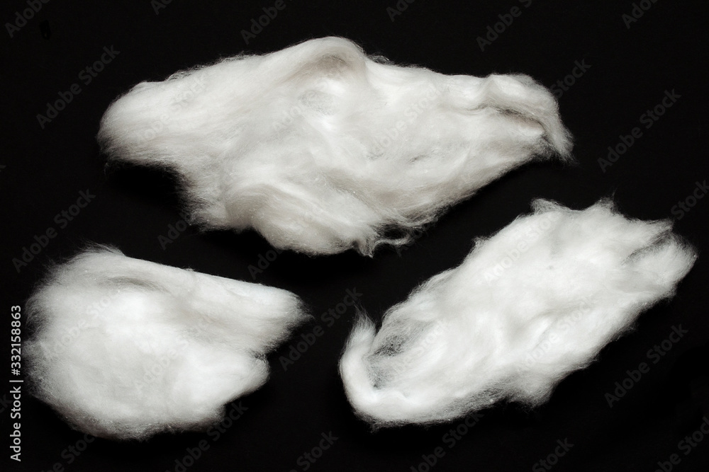 Clouds made of cotton wool isolated on black background. Three clumps ...