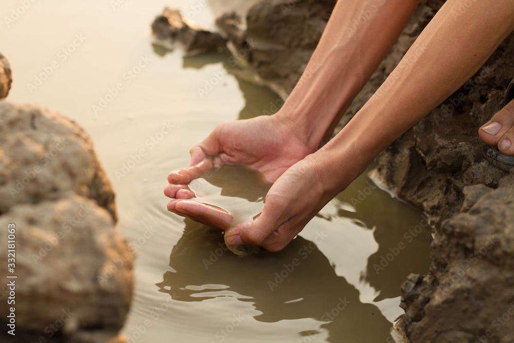Hand taking water from dirty pond metaphor freshwater scarcity ...