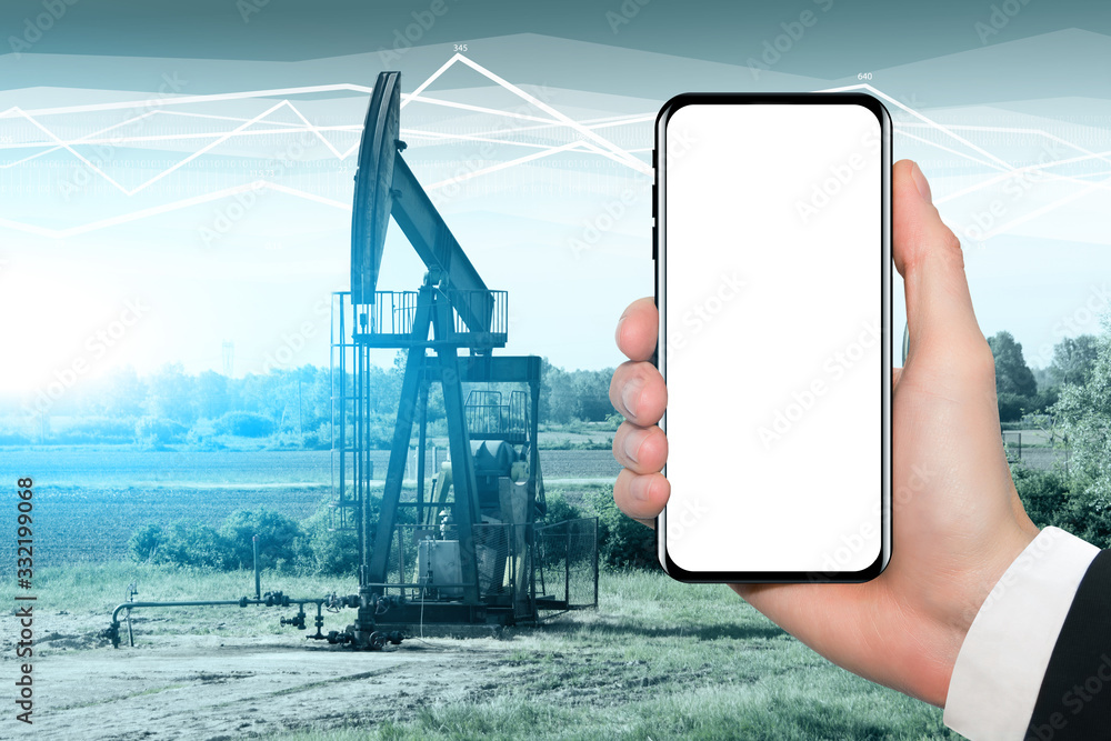 Hand with phone on the background of oil rigs. White screen, you can ...