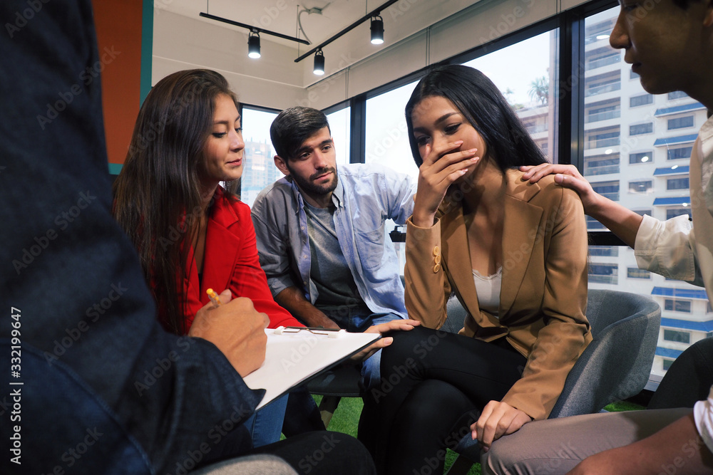Group of stressed people comforting their friend in psychotherapy ...