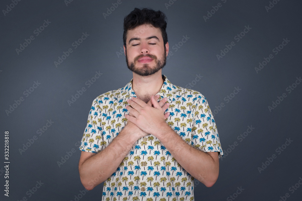 Faithful man closes eyes and keeps hands on chest near heart, shows his ...