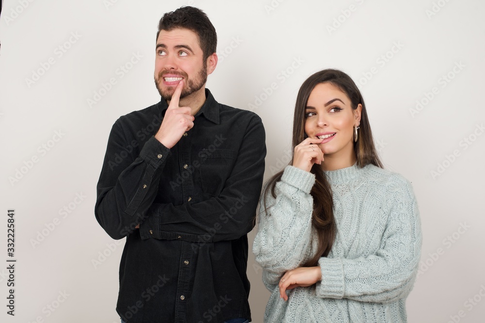 Dreamy female with thoughtful expression, looks to the camera, keeps ...