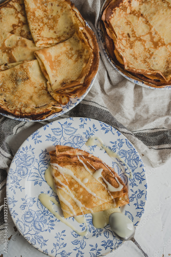 Crepe with condensed milk on a vintage plate and linen background ...