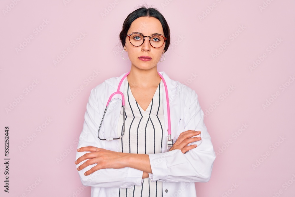 Beautiful doctor woman with blue eyes wearing coat and stethoscope over ...