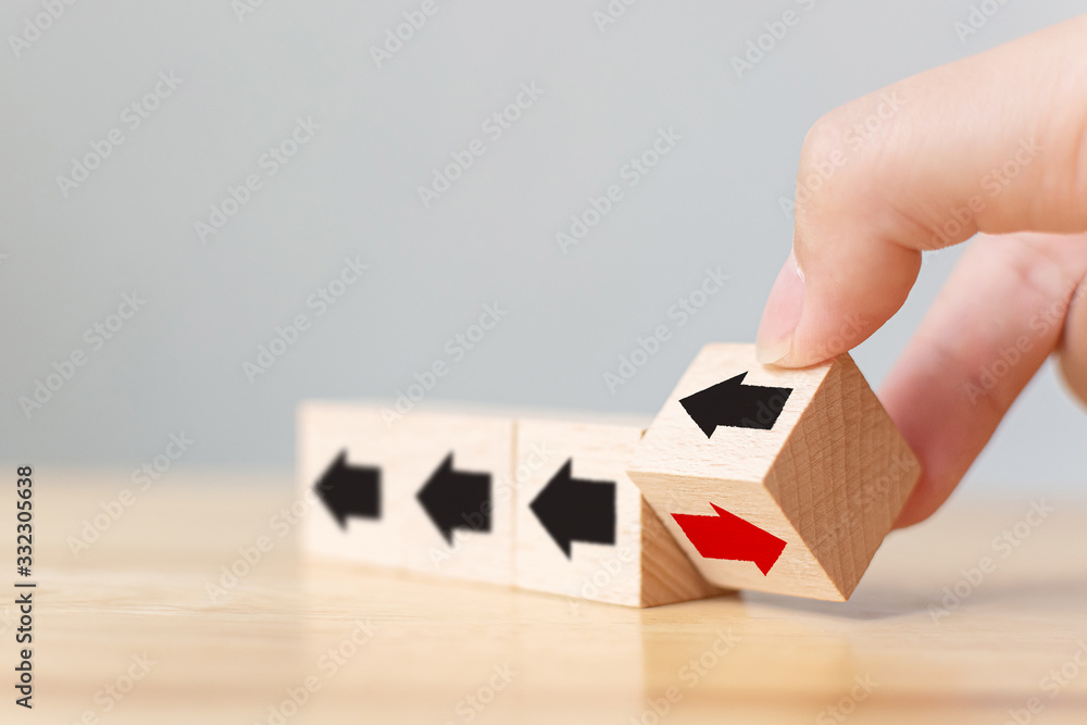 Hand flip over wooden cube block with red arrow facing the opposite ...
