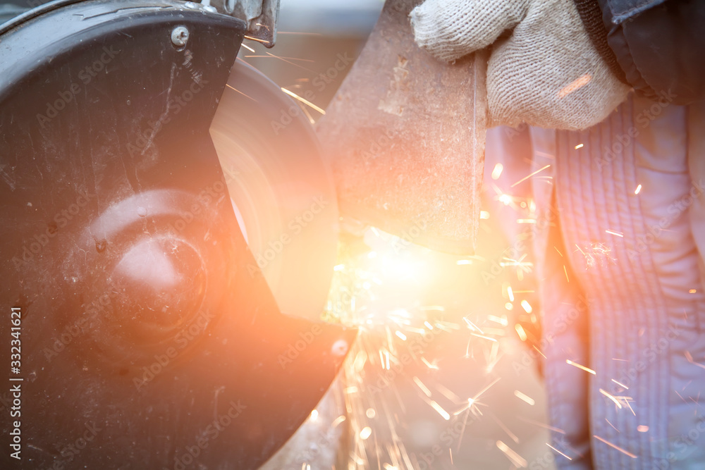 master in gloves and blue jacket sharpens axe on electric sharpener ...
