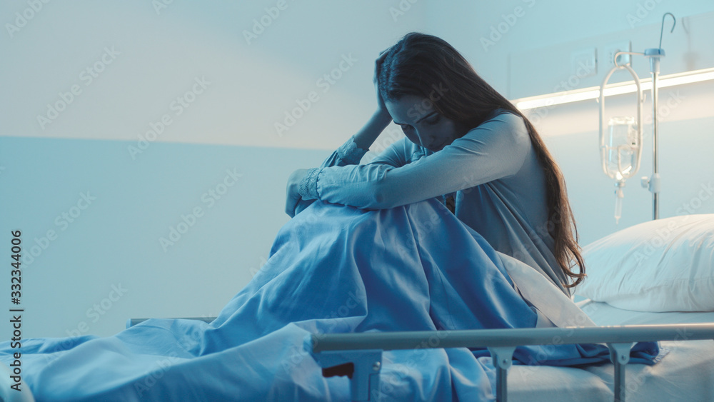 Sad female patient lying in a hospital bed at night Stock Photo | Adobe ...