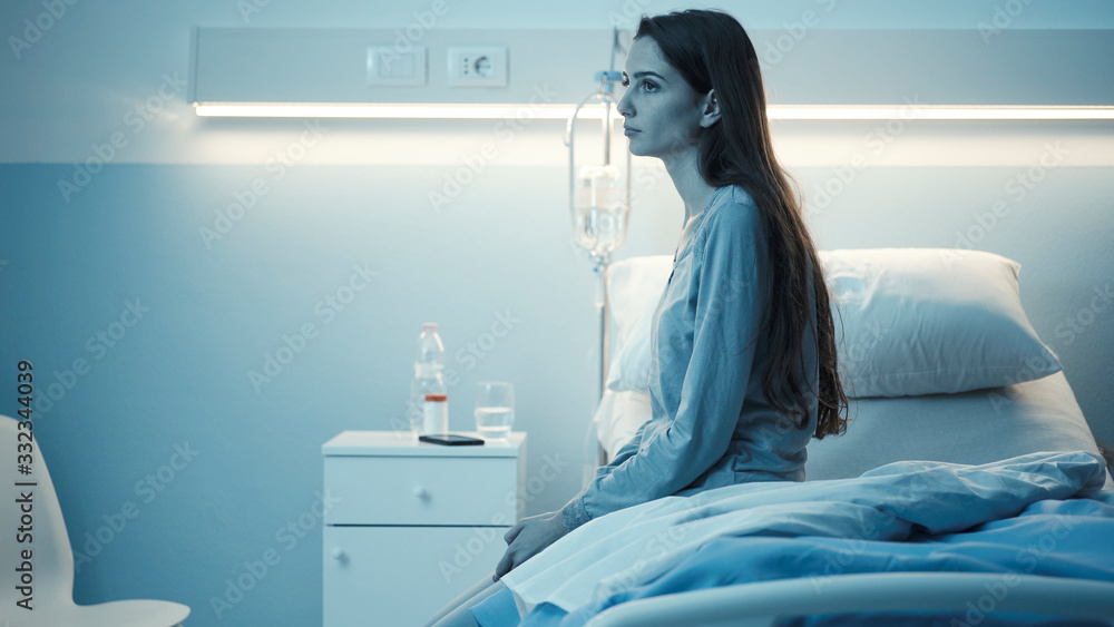 Sad sleepless patient sitting on the hospital bed at night Stock Photo ...