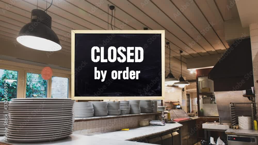 Closed by order sign swinging on empty restaurant pizza kitchen worktop ...