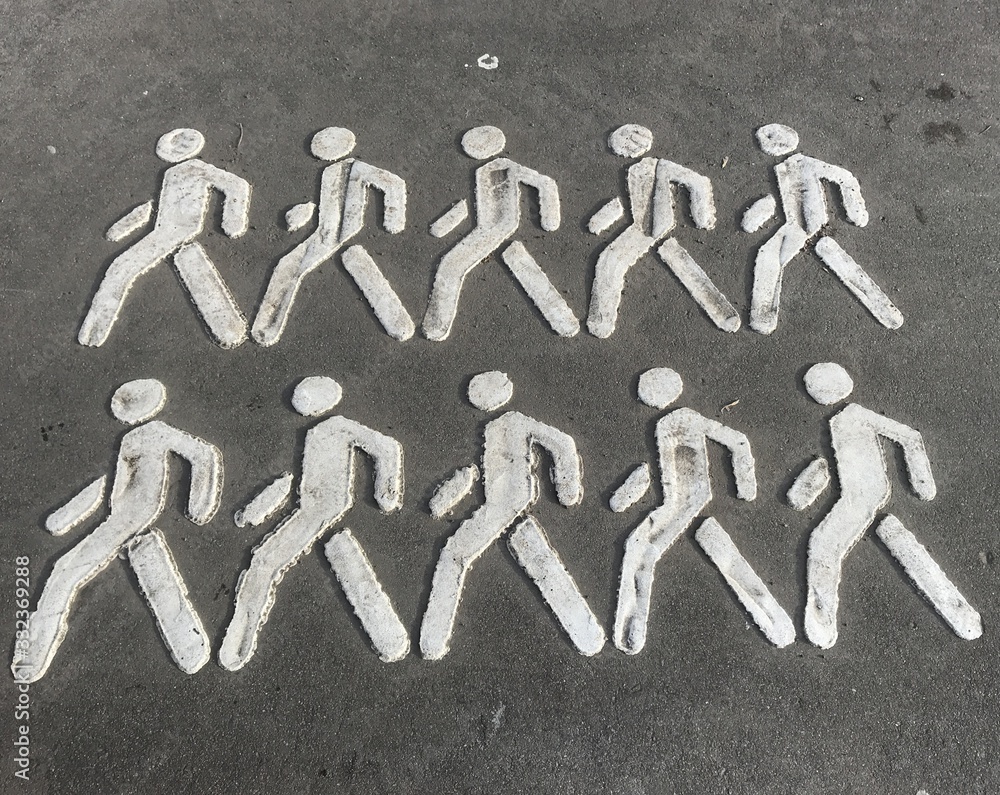 The texture of the white figures of people walking on the grey pavement ...
