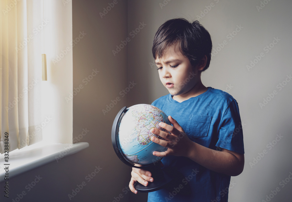 Self isolation Kid looking at globe learning about virus spreading ...