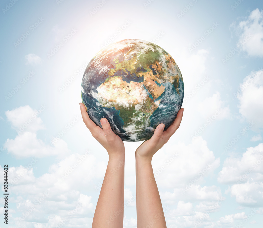Child hands holding planet earth over blue sky background with copy ...