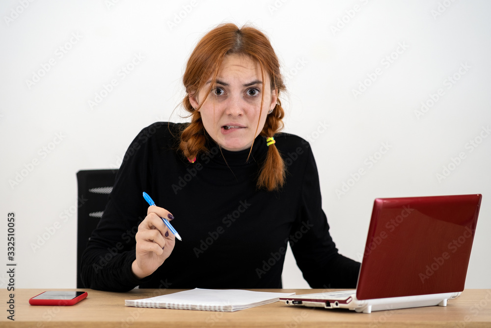 Shocked serious young office worker woman sitting behind working desk ...