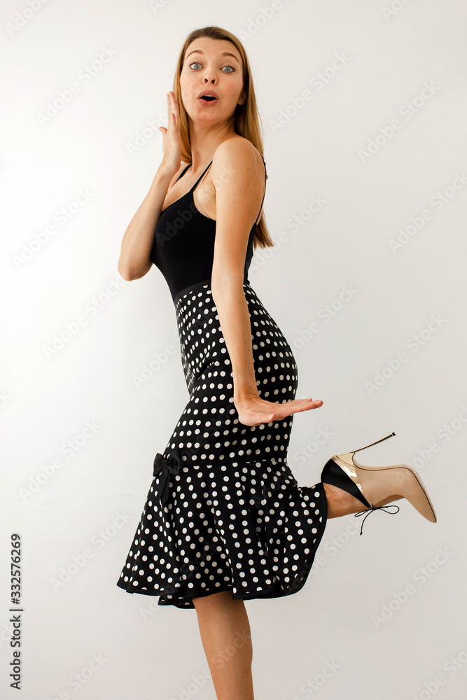 From below side view of playful adult woman in black dress with polka ...