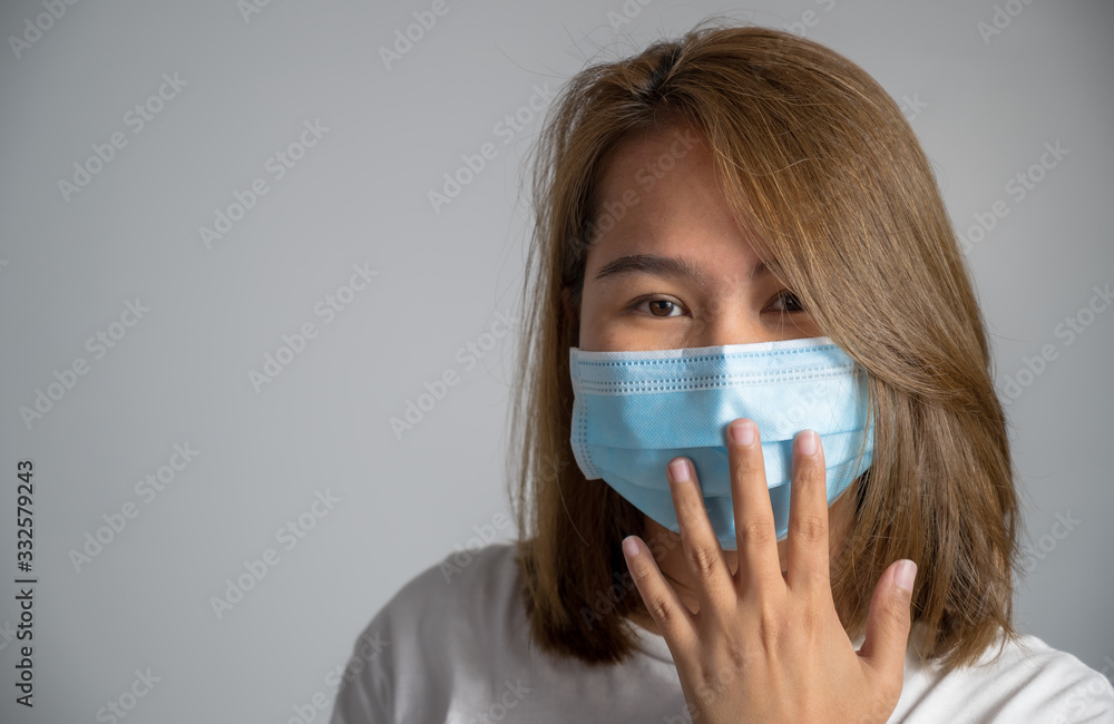 Asian young woman wearing a hygiene protective mask over her face on ...