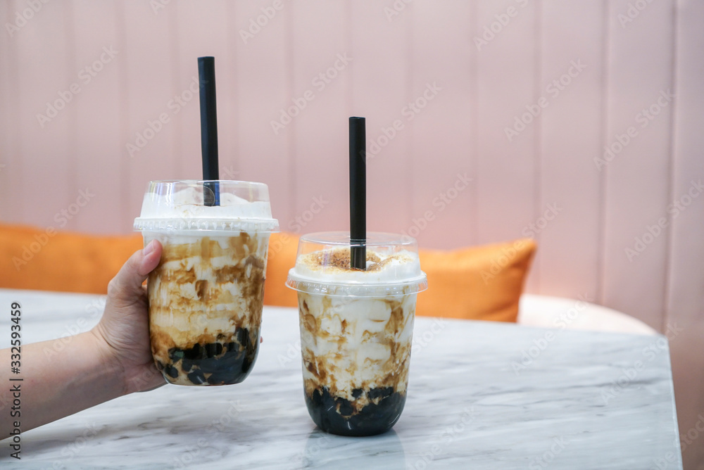 Iced fresh milk and milk tea with brown sugar bubble. Two plastic cup ...