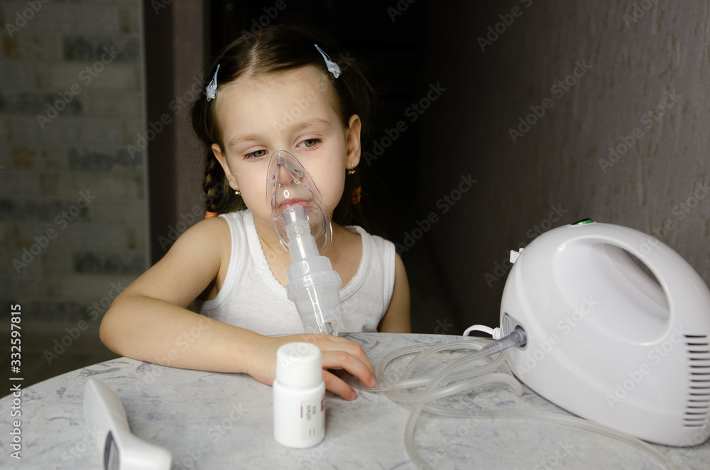 A Child Sits With An Inhaler At Home Coronovirus Treatment Concept