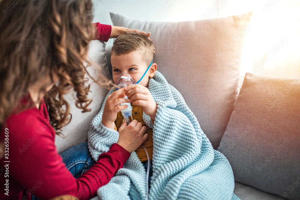 Causian little boy making inhalation with nebulizer at home. Child ...