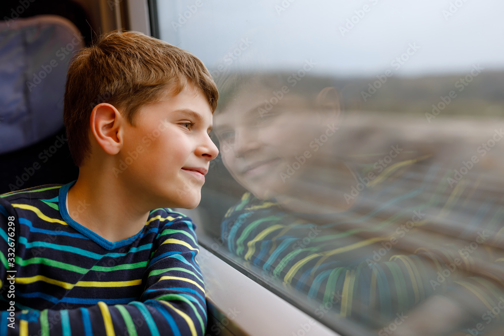 Adorable kid boy traveling by train. Happy smiling child looking out of ...