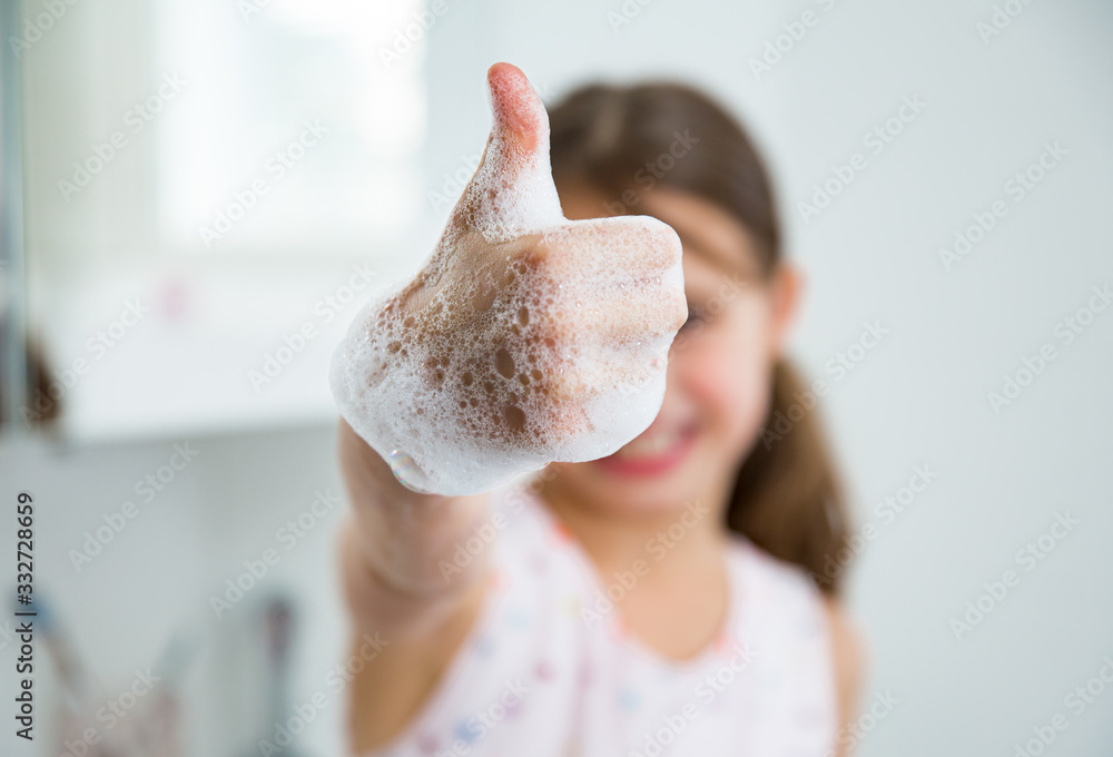Little girl washing hands with water and soap in bathroom. Kid showing ...