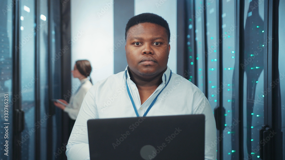 Portrait of handsome african IT specialist using tablet working in ...