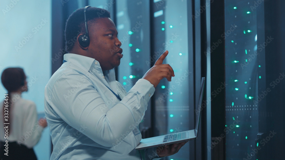 Busy african IT service support technician talking performing working ...