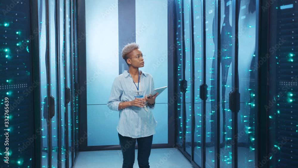 Black female administrator with tablet activating network servers in ...