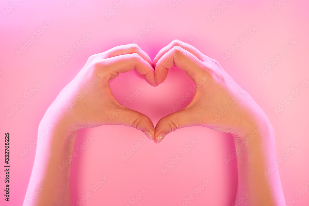 Young woman's hands made gesture of heart shape in trendy neon light on ...