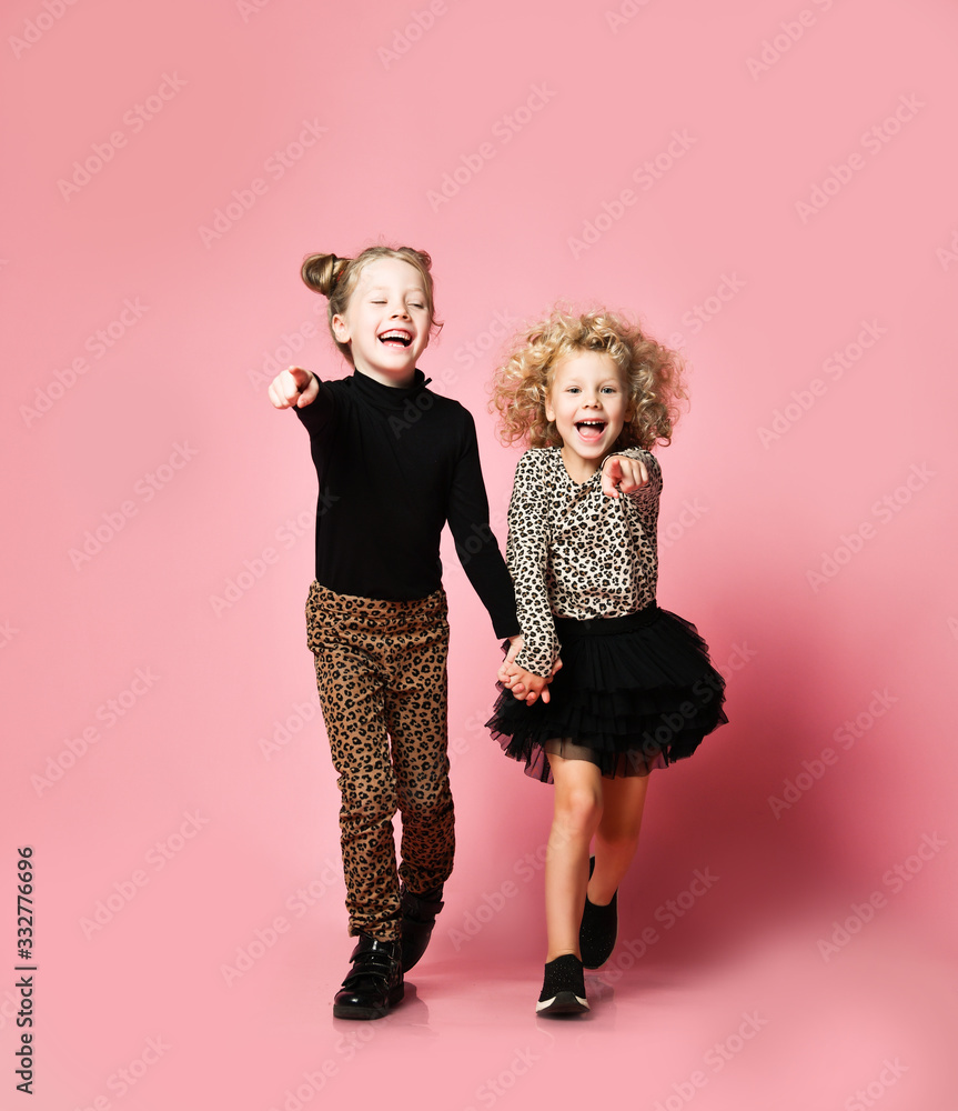 Laughing kids girls friends sisters in leopard print clothes pants and ...