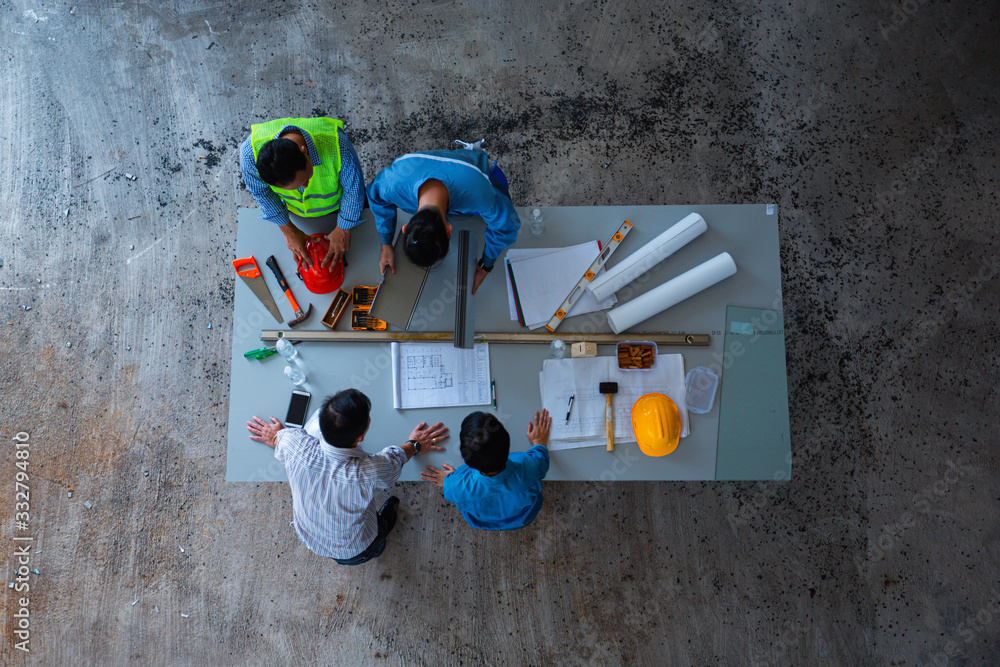 Top view of architectural engineer working on his blueprints with ...
