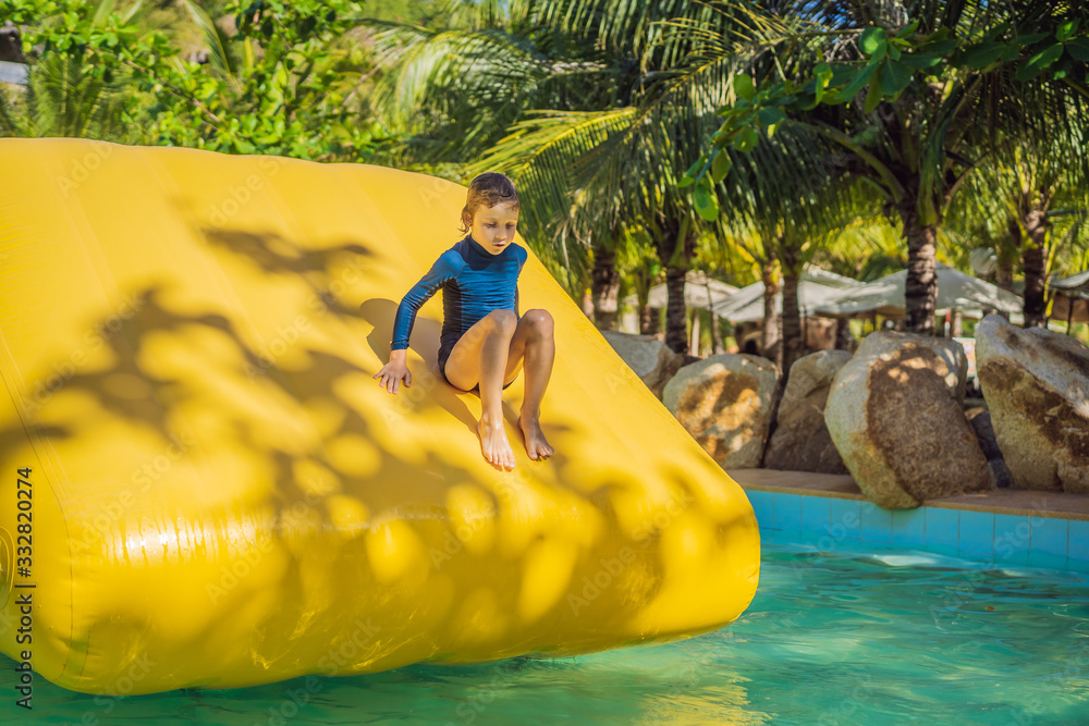 Cute boy runs an inflatable obstacle course in the pool Stock Photo ...