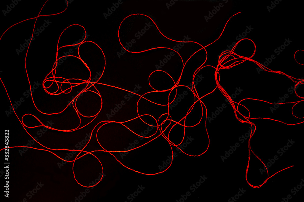 Colorful red thread in various curved shapes on a black background ...
