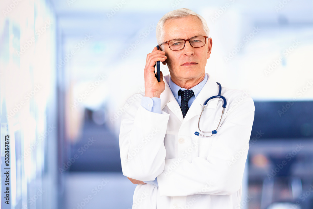 Elderly doctor talking with his patient on his mobile phone while ...
