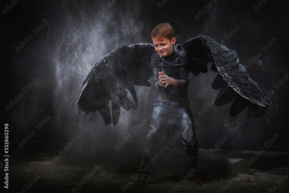 Black evil angel on a dark background with colored lighting. The ...