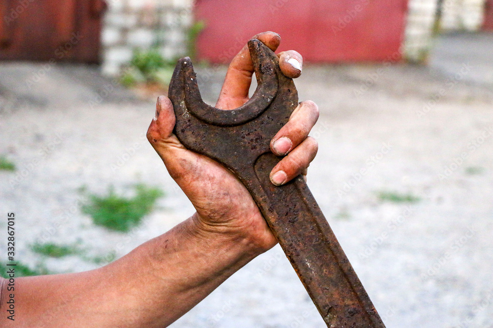big old rusty wrench is held by male dirty calloused hands. Stock Photo ...
