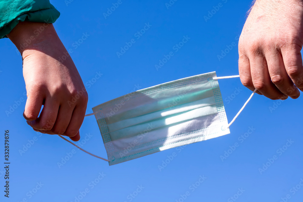 man and woman holding a medical mask between hands, male and female ...