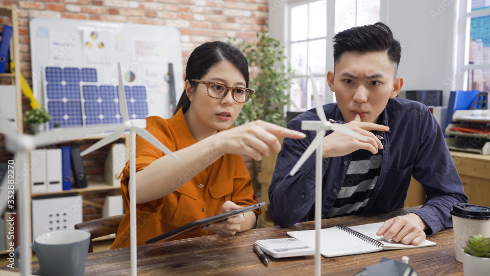 Young successful female engineer worker explaining basics of wind power ...