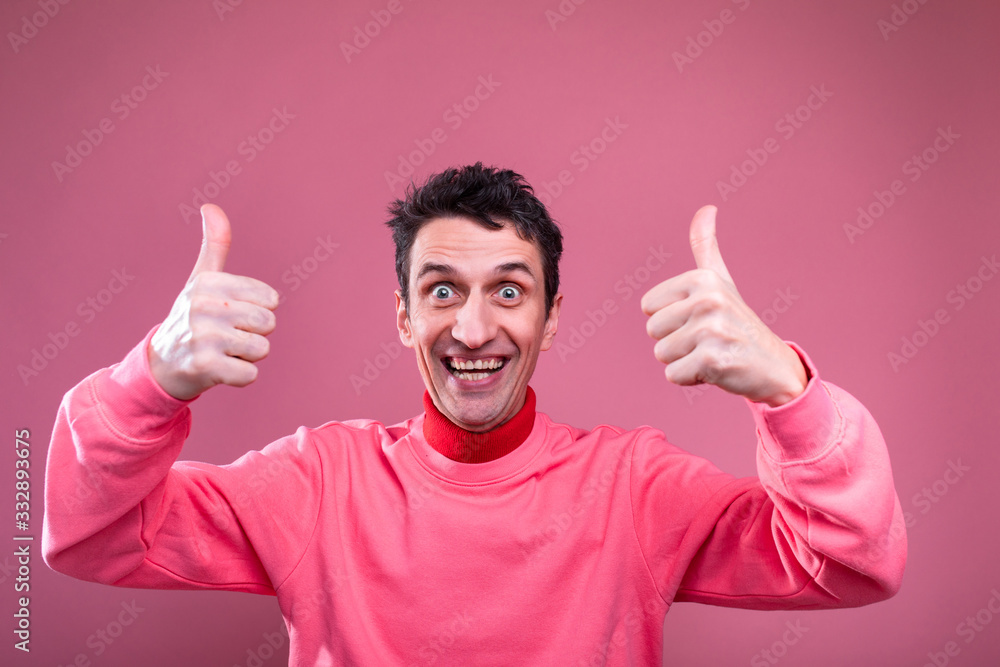 Emotional positive young smile and hold big thumbs up. Cheerful guy ...