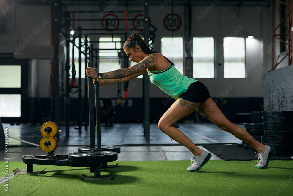 Sportswoman pushing weights. Stock Photo | Adobe Stock