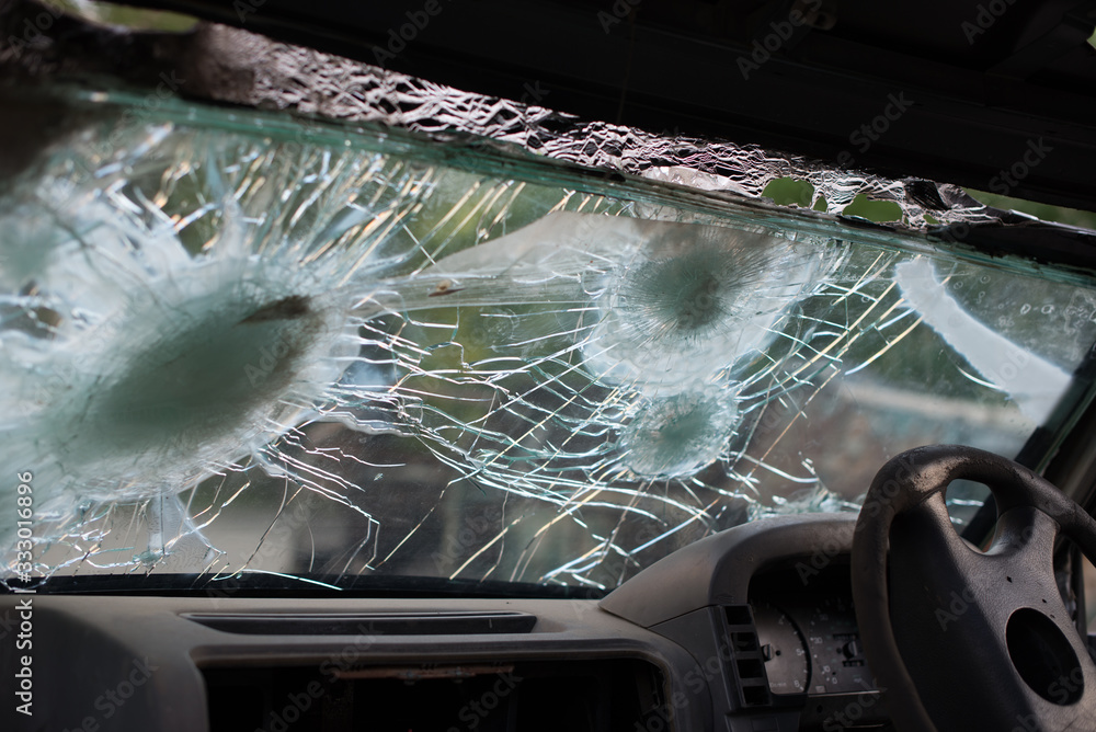 Bullet hole on a car windshield. Car window after a raid has a bullet ...