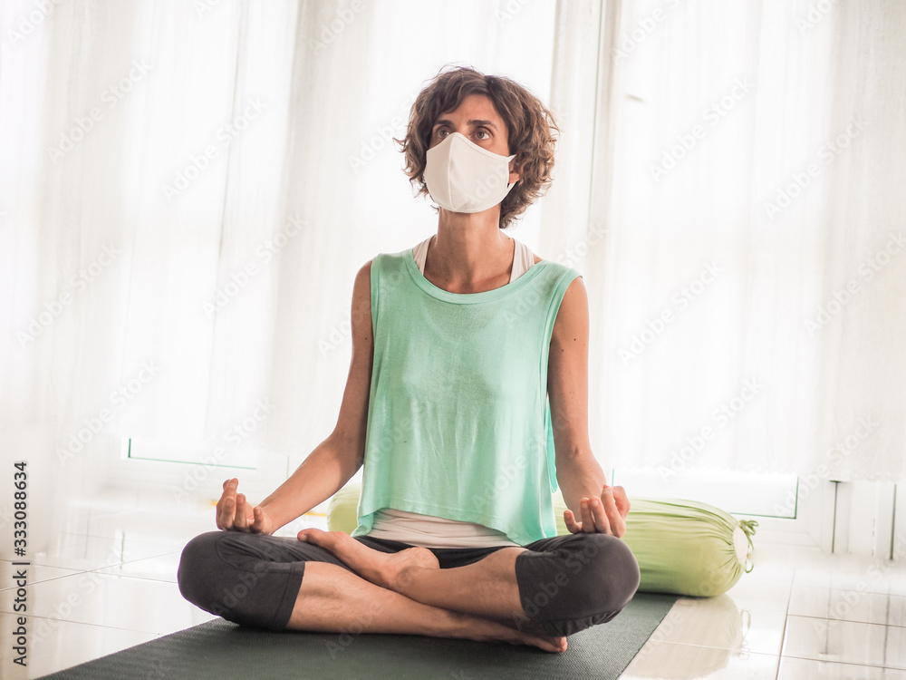 meditating woman wearing a medical face mask to protect from corona ...