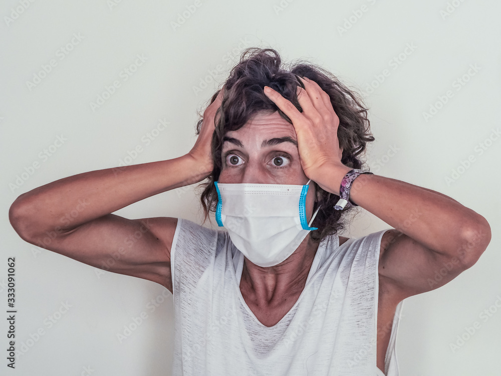 worried and scared woman wearing a white medical face mask that ...
