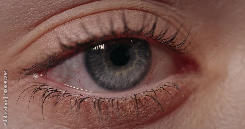 Extreme close up of a watery blue eye opening, blinking and closing ...