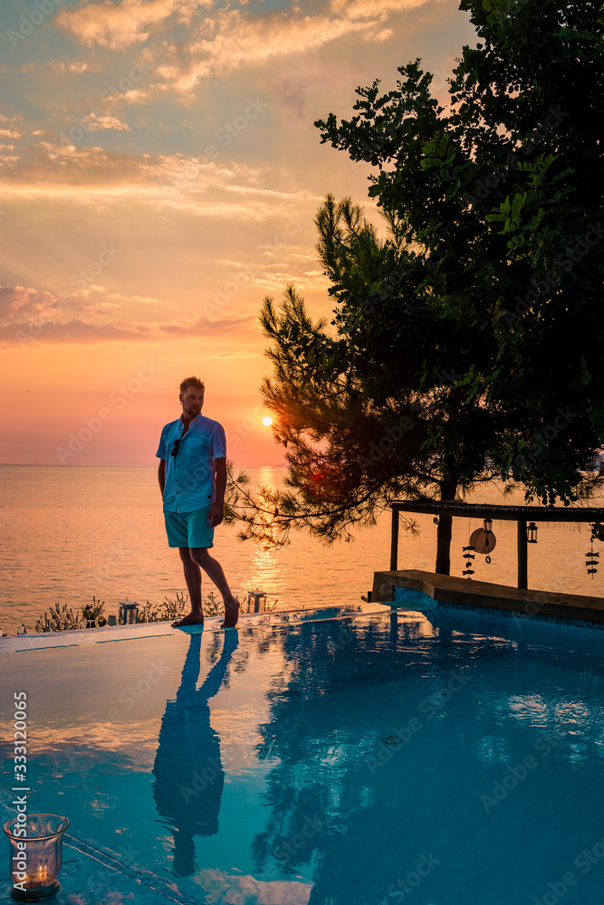 Fethiye Turkey, young guy in swim short watching sunset by the pool ...